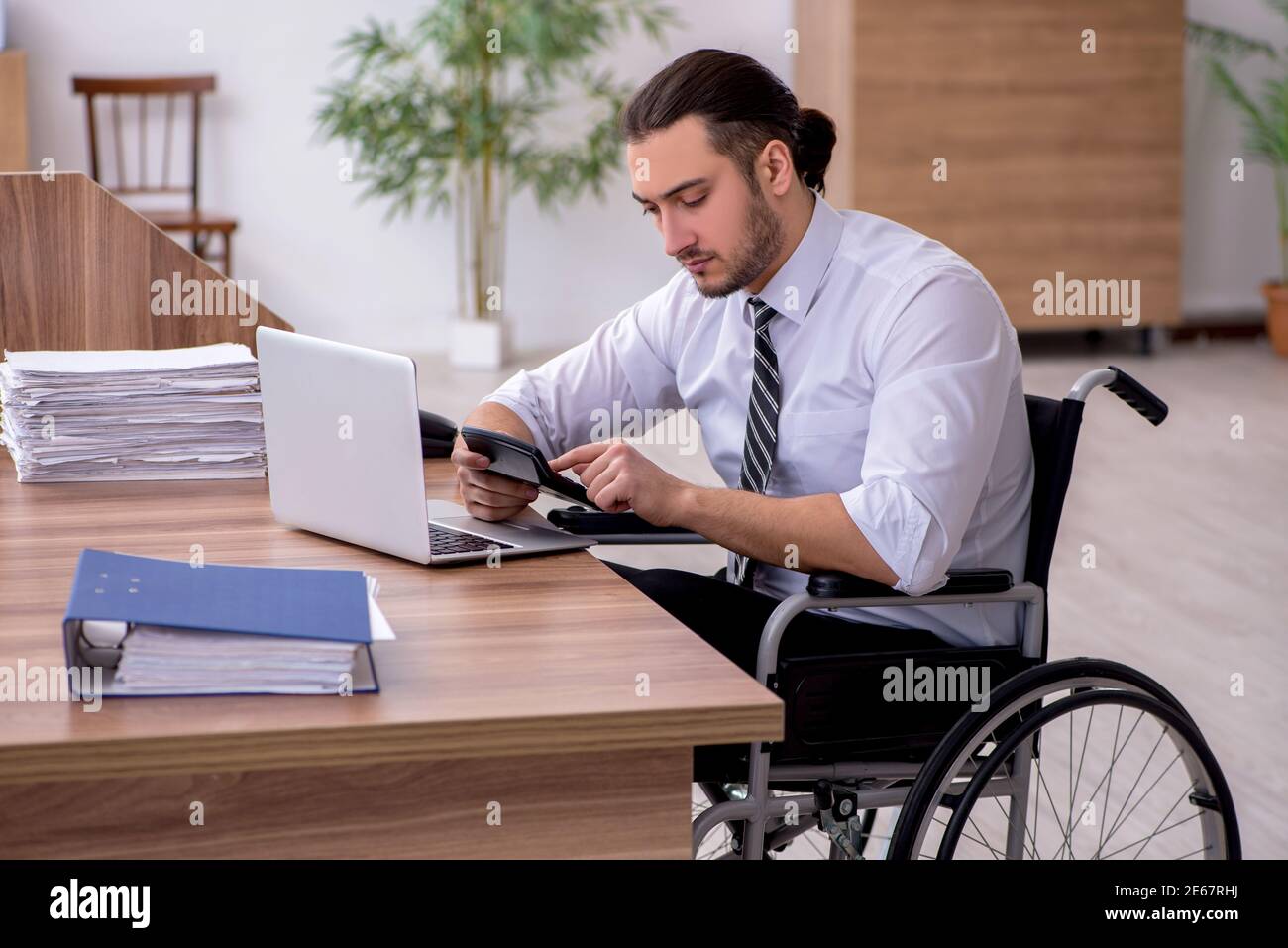Young disabled employee suffering at the workplace Stock Photo - Alamy