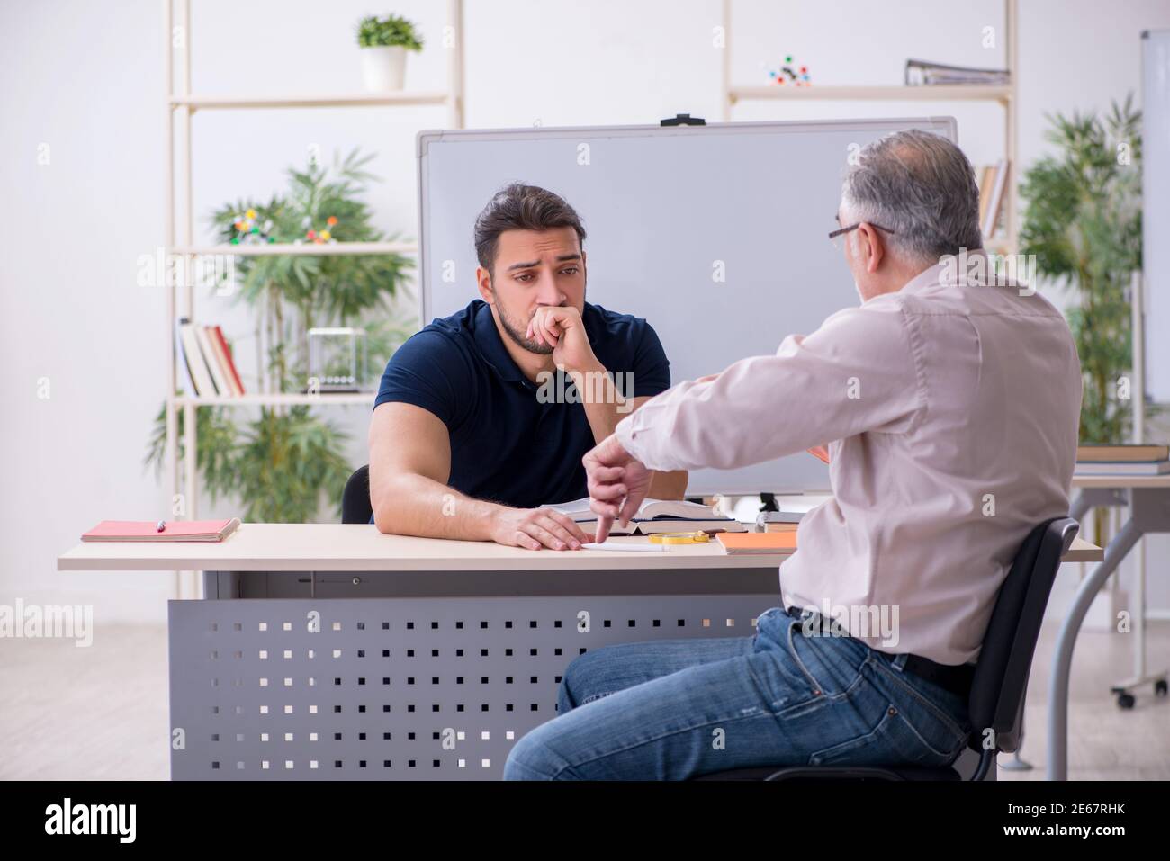 Old teacher and young student in the classroom Stock Photo - Alamy