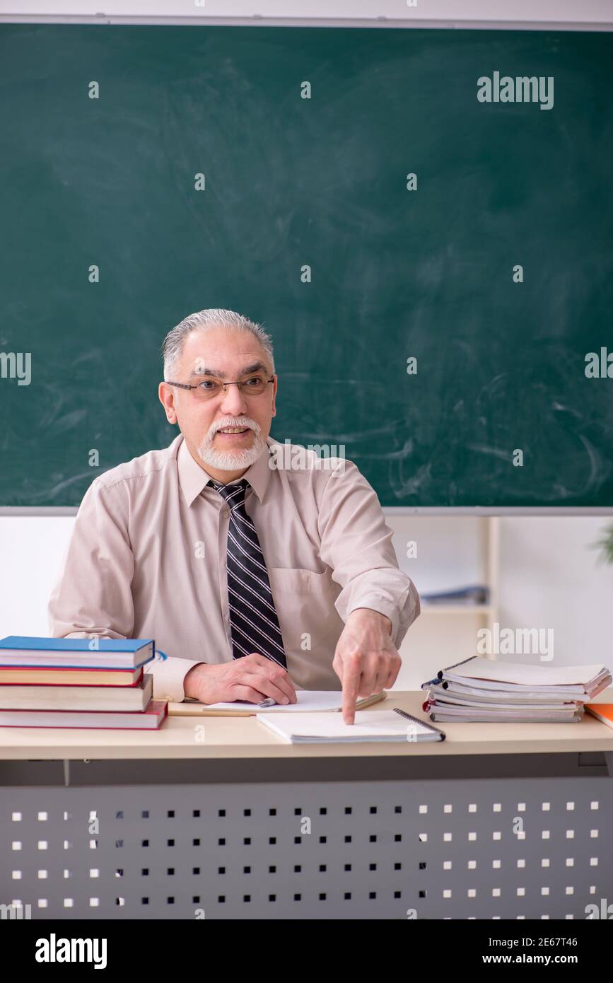Old experienced teacher in the classroom Stock Photo - Alamy