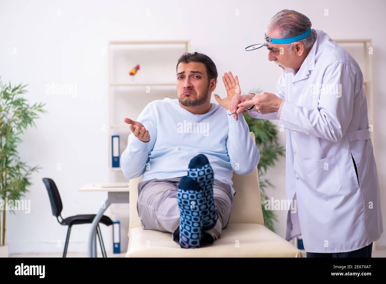 Sick man visiting old doctor otolaryngologist Stock Photo - Alamy