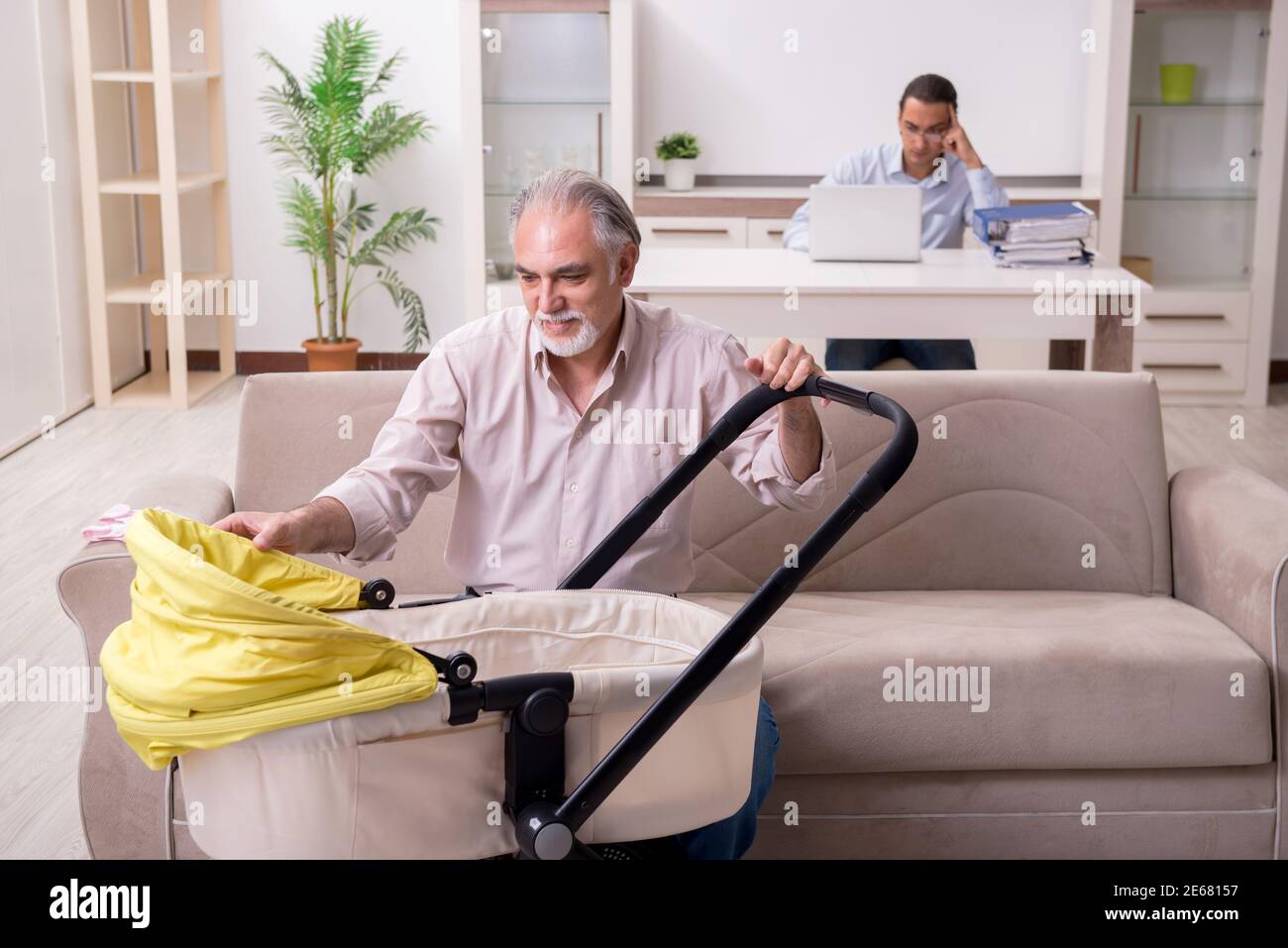 Old grandfather looking after newborn at home Stock Photo - Alamy