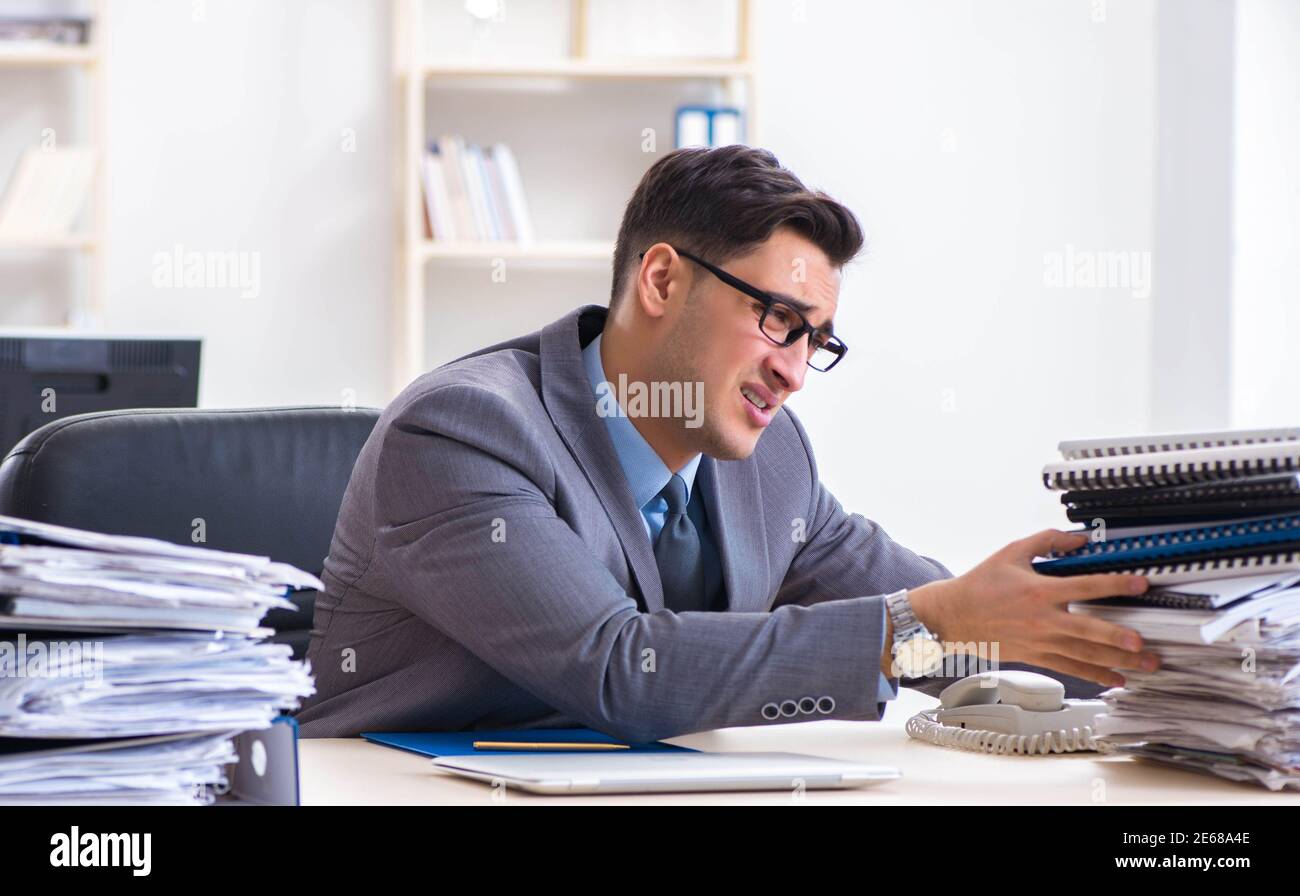 The overloaded with work employee under paperwork burden Stock Photo ...