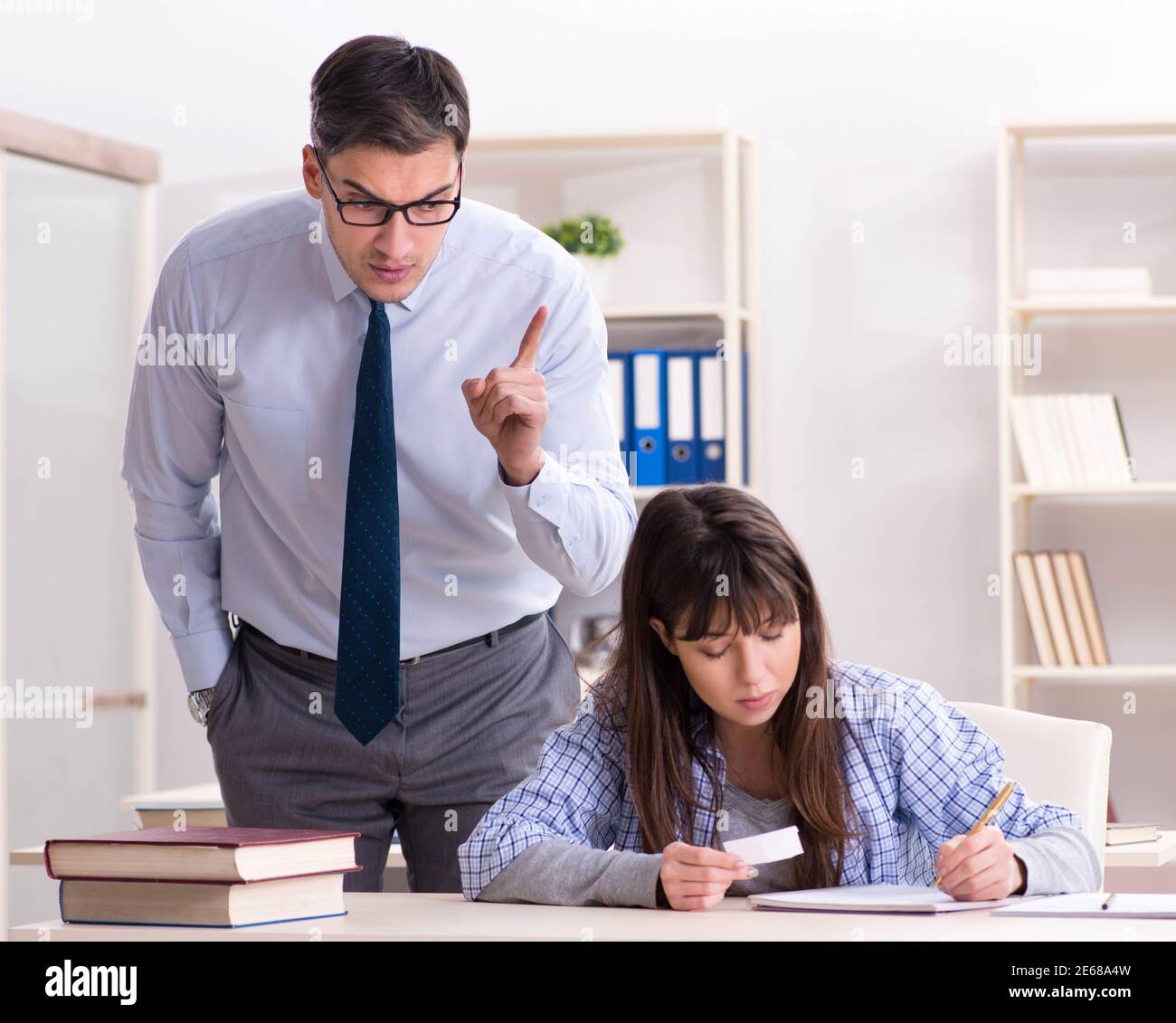 The male lecturer giving lecture to female student Stock Photo - Alamy