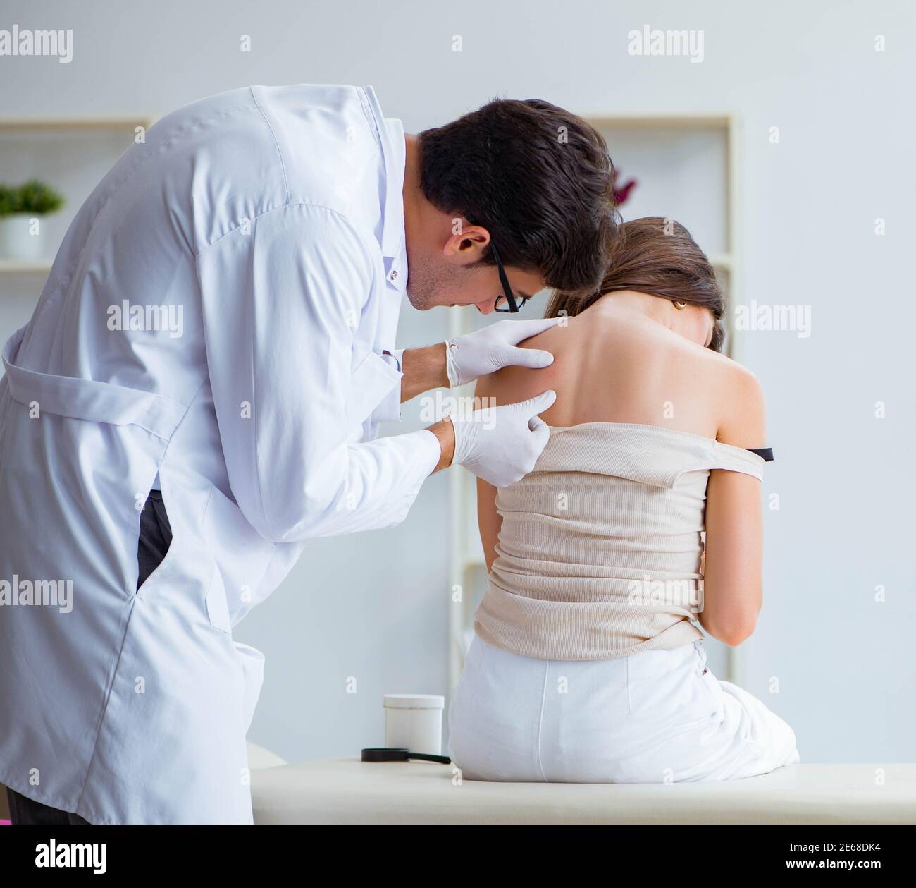 The doctor examining the skin of female patient Stock Photo - Alamy