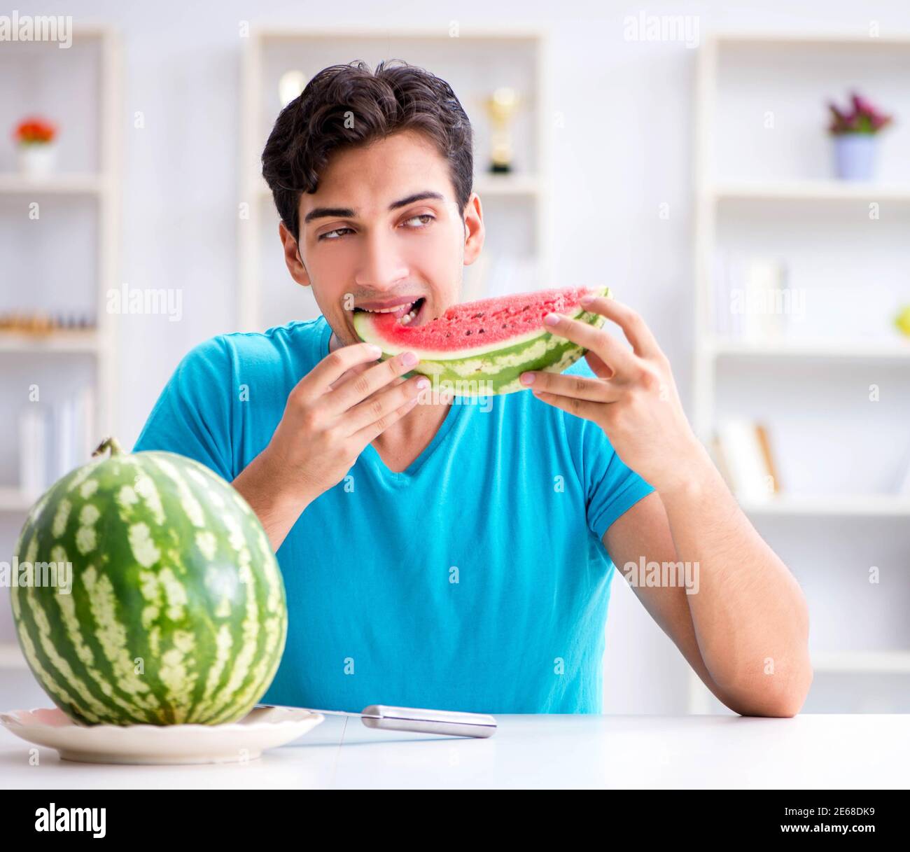 The man eating watermelon at home Stock Photo - Alamy