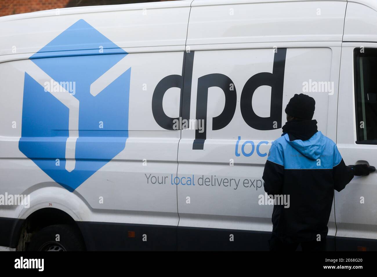 London, UK. 28th Jan, 2021. A DPD delivery driver stands next to the ...