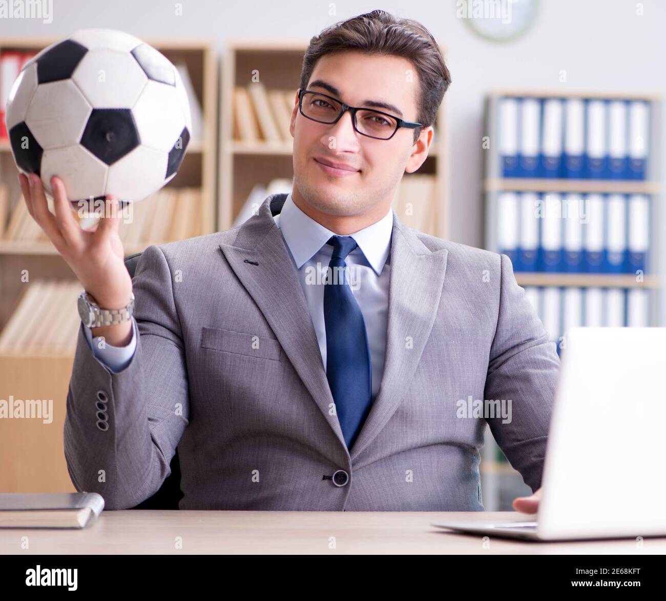 The businessman with football ball in office Stock Photo - Alamy
