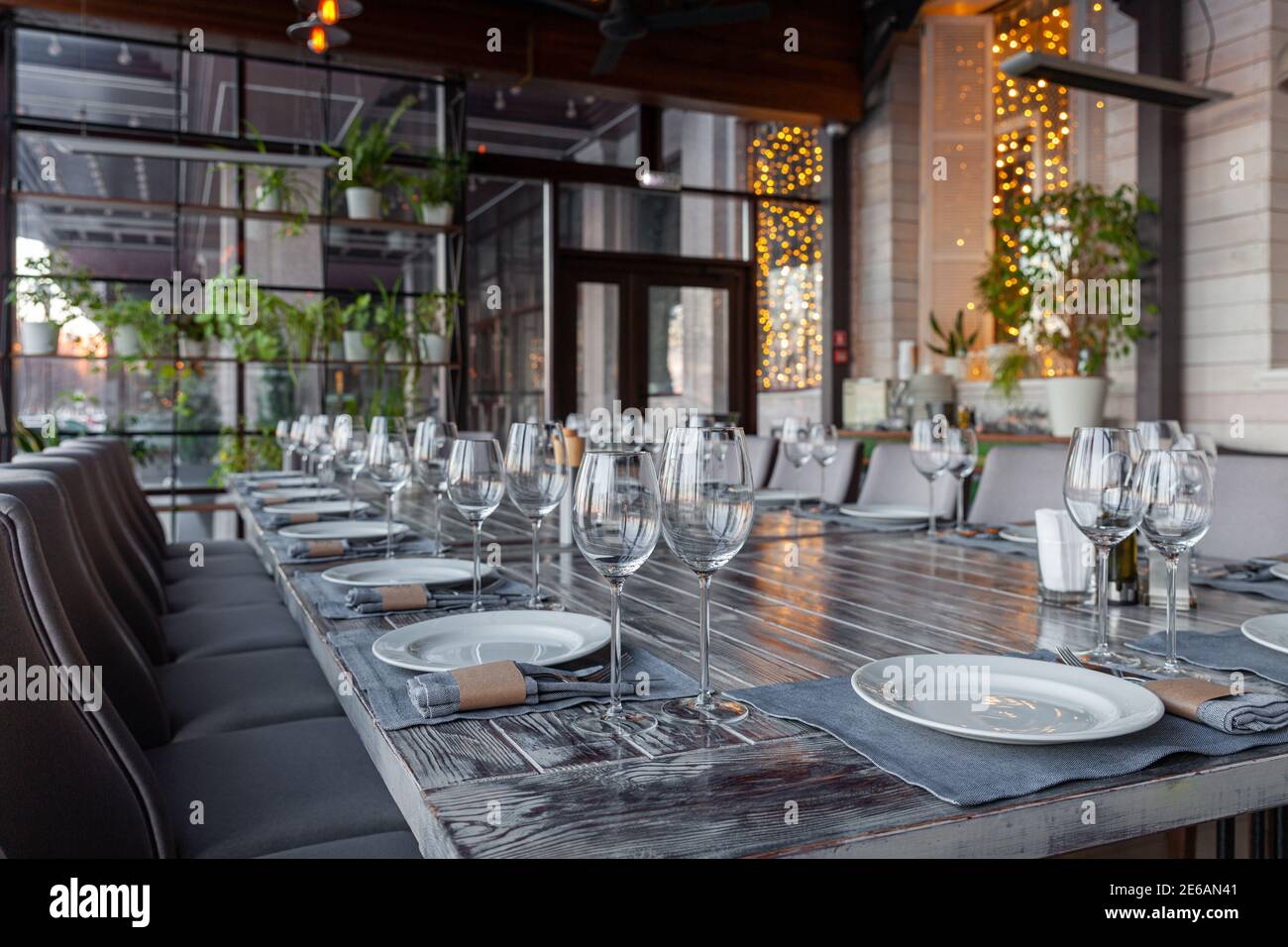 Modern veranda restaurant interior, banquet setting, glasses, plates ...