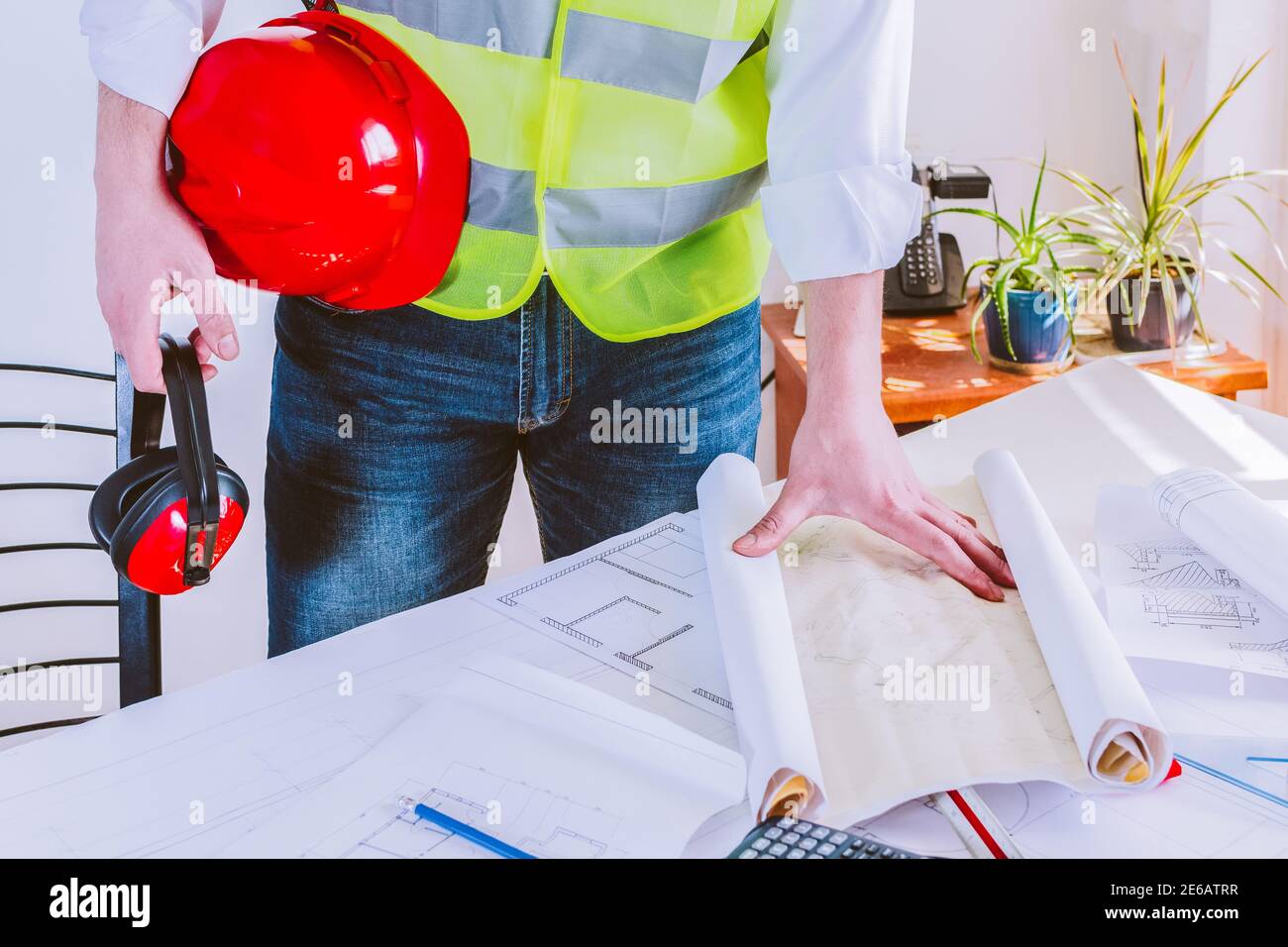 Young engineer wearing yellow safety vest with red helmet and ...