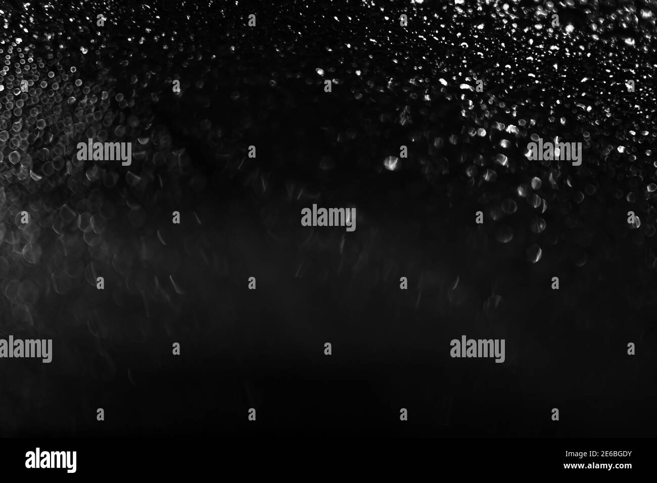 Water droplets on glass at night, dark background. Black and white ...