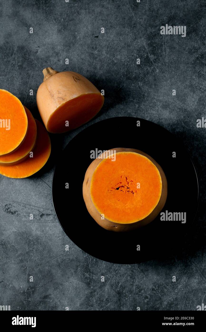 Vertical top view of sliced butternut squash on a dark bowl isolated ...