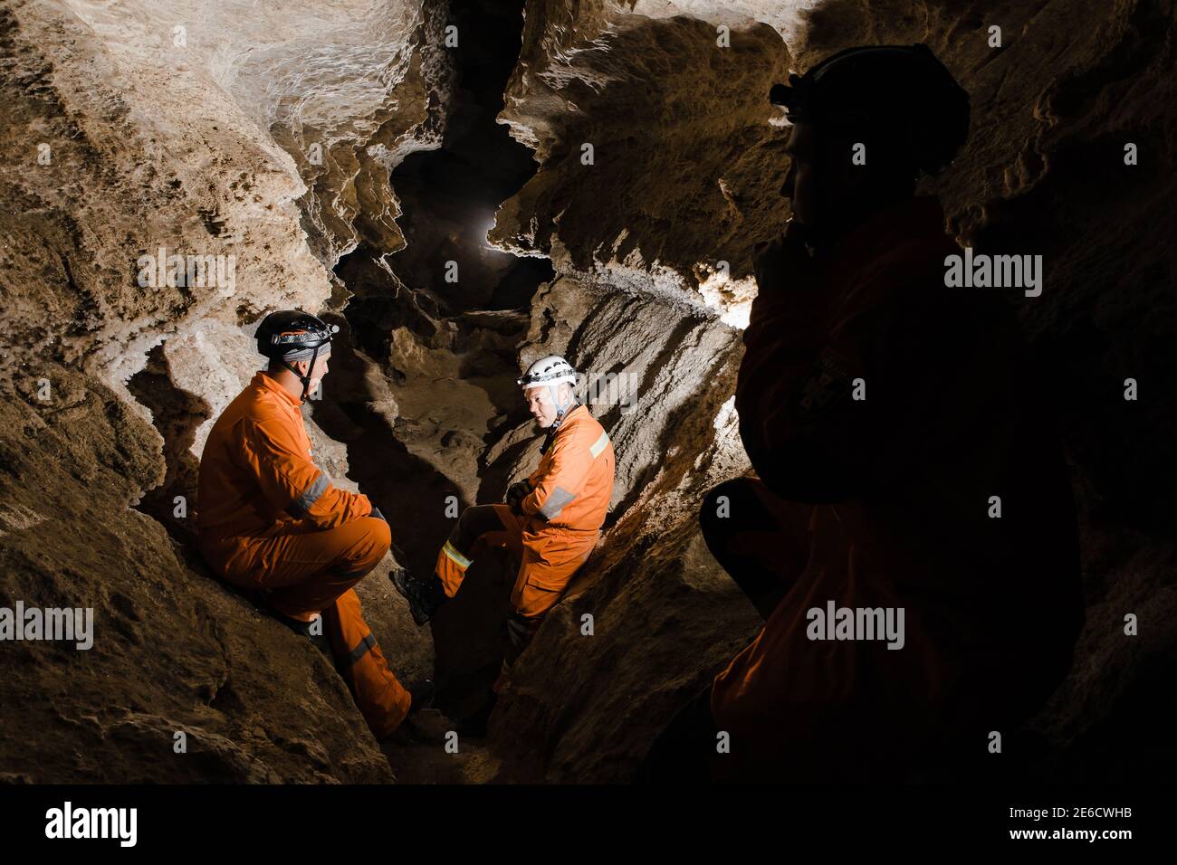 Three men, strong physique, explore the cave. Men dressed in special ...