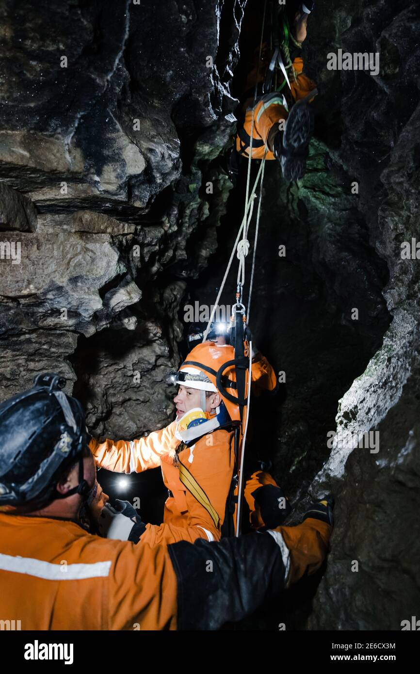 Cave rescuer helping injured climber Stock Photo - Alamy