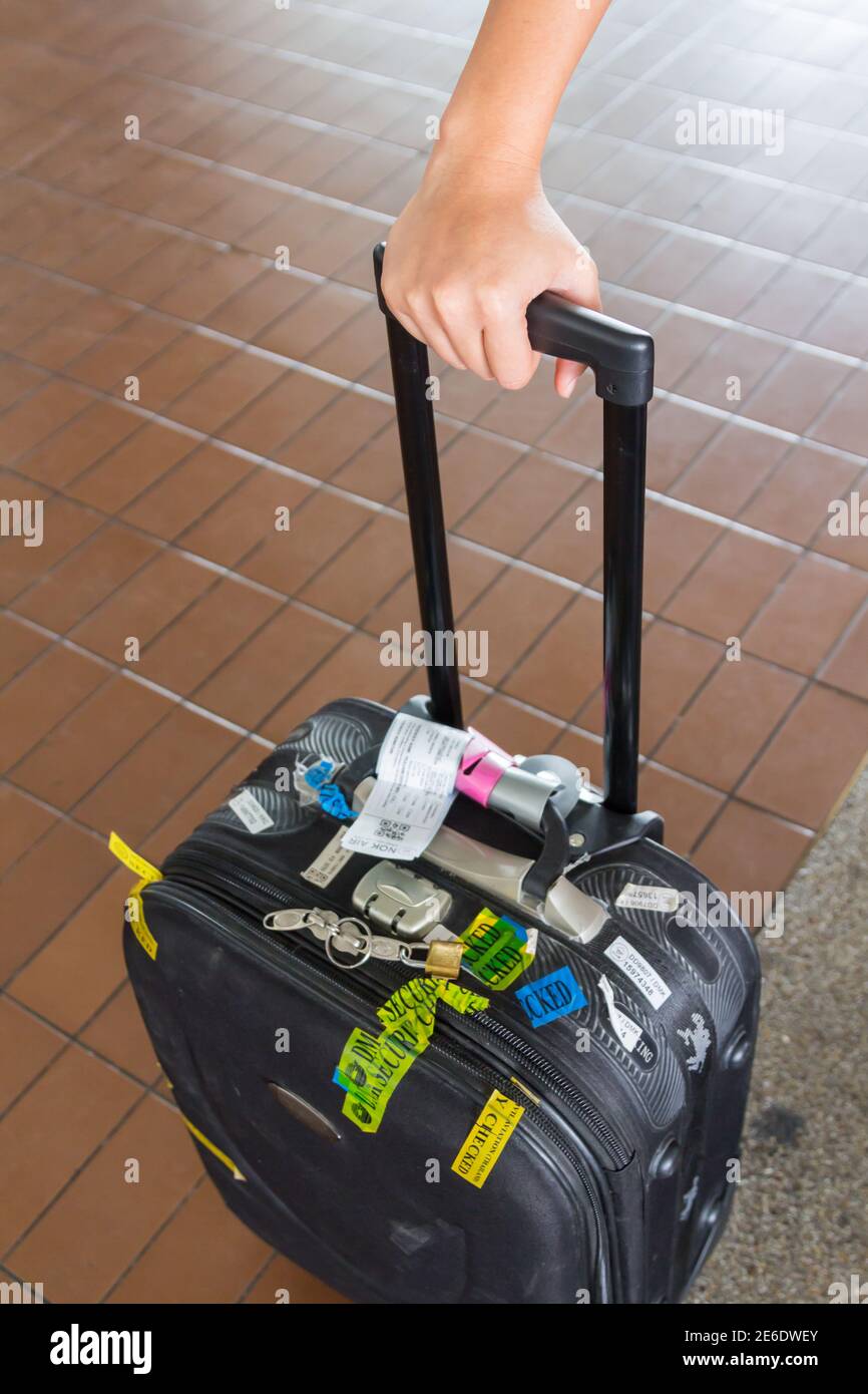 Hand dragging a travel suitcase Stock Photo - Alamy
