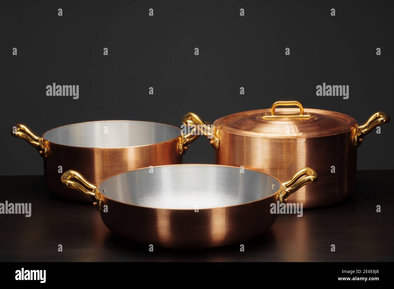 Shiny vintage copper cookware over dark background Stock Photo - Alamy