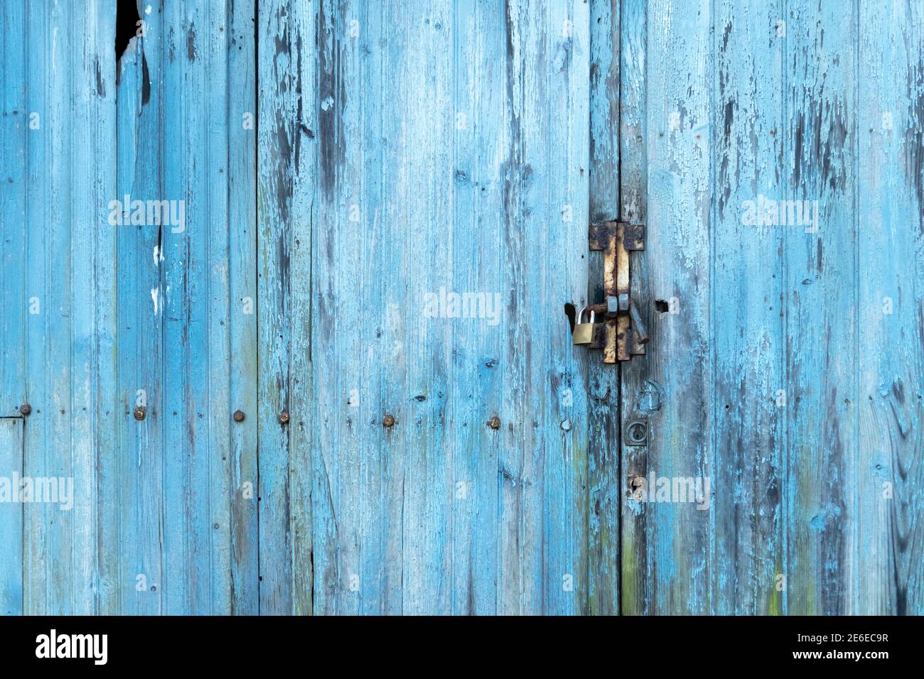Plank old blue weathered gate with a keyhole and a padlock with rusted ...