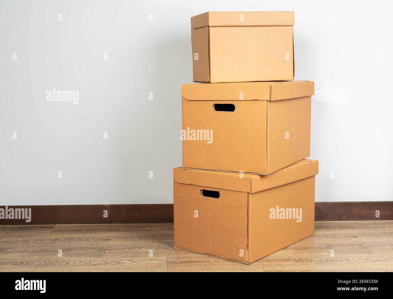 Group of brown carton boxes on wooden floor Stock Photo - Alamy