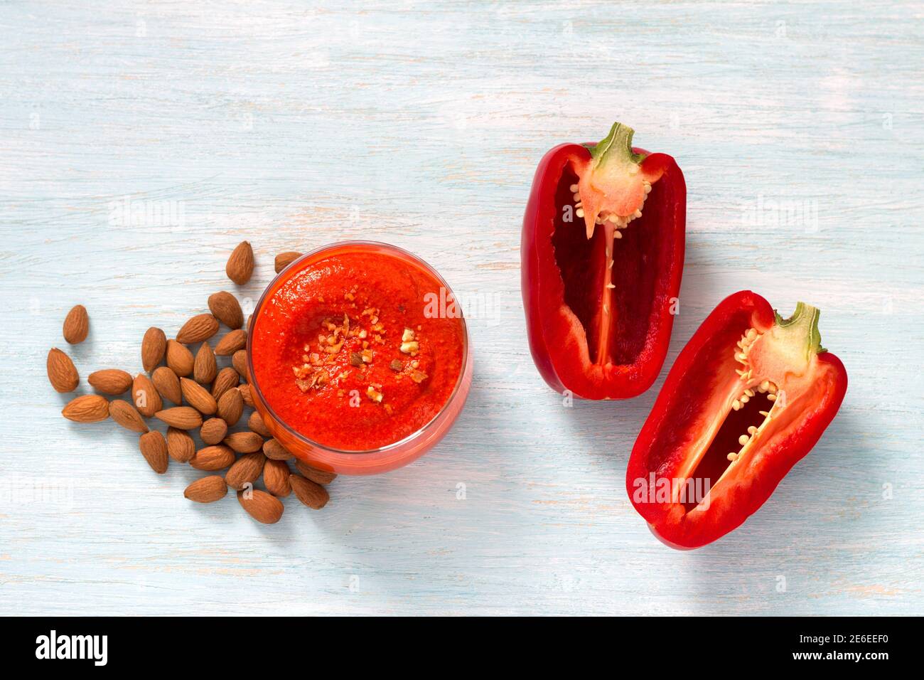 Homemade baked sweet bell pepper dip with almonds on a light blue ...