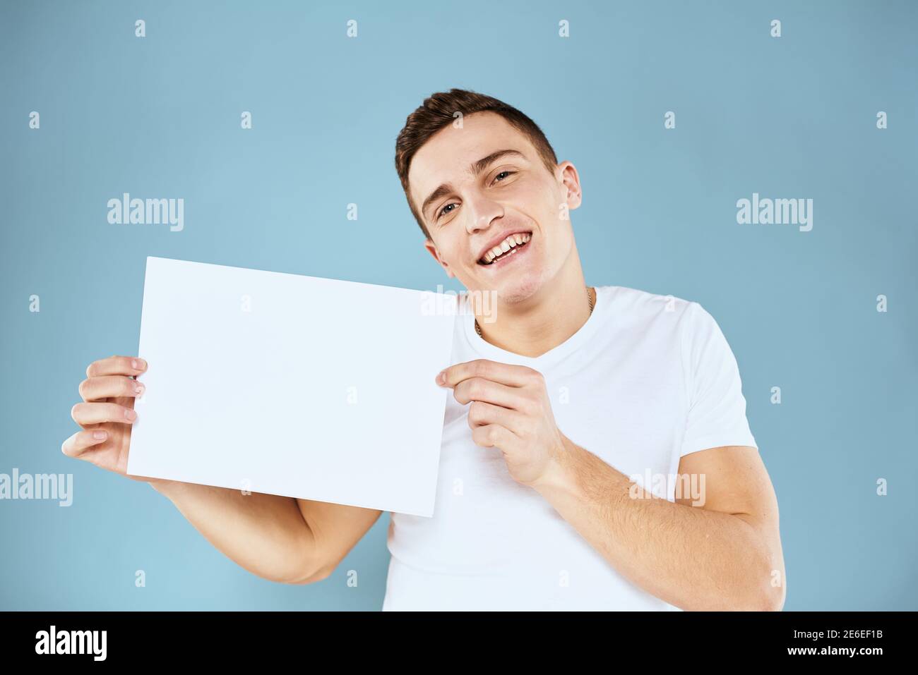 man holding a sheet of paper in his hands white t-shirt cropped view ...