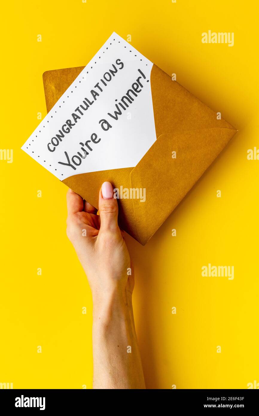Female hand holds envelope with card You are a winner. Congratulations ...