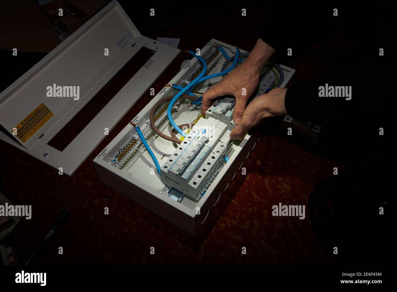 Electrician refitting and testing a new fuse board and safety checking ...