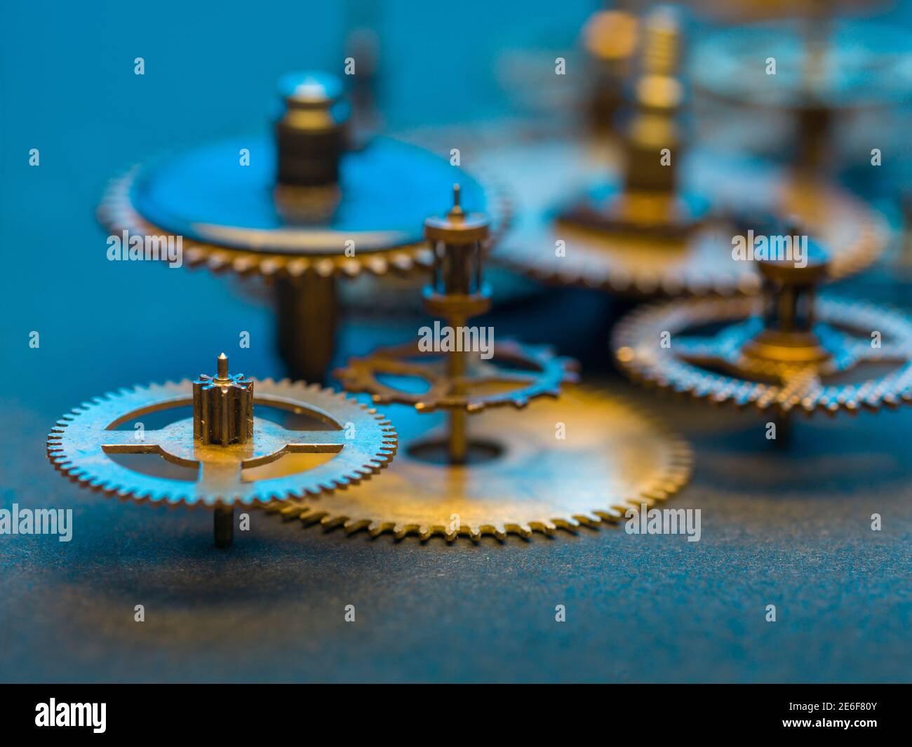 Close view on golden cogs and wheels on blue background Stock Photo - Alamy
