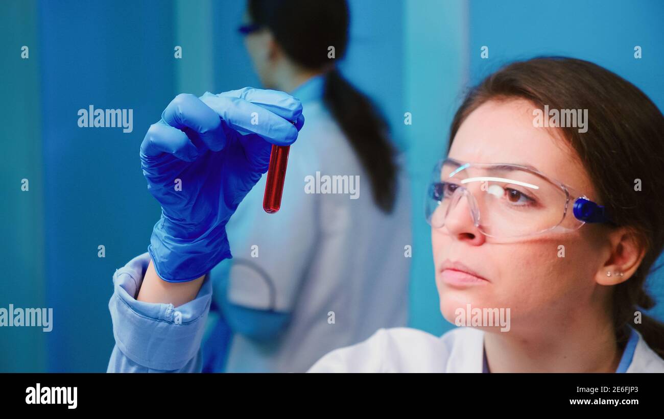 Scientist woman examining blood samples and liquid working in modern ...