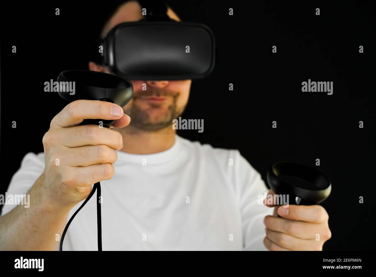 Man wearing VR headset and using hand controllers in virtual reality ...