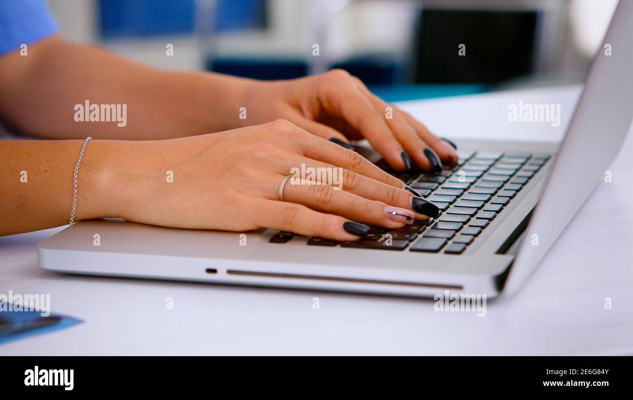 Close up of medical assistant typing patient health report on laptop ...