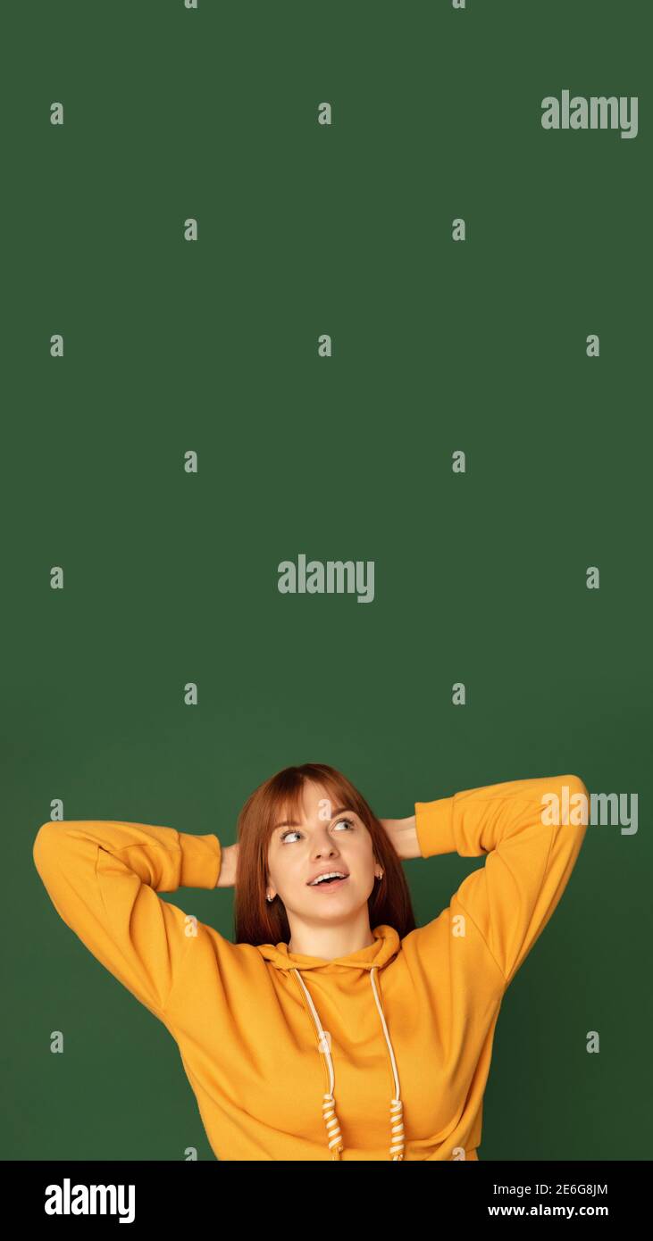 Resting. Caucasian woman's portrait isolated on green studio background ...