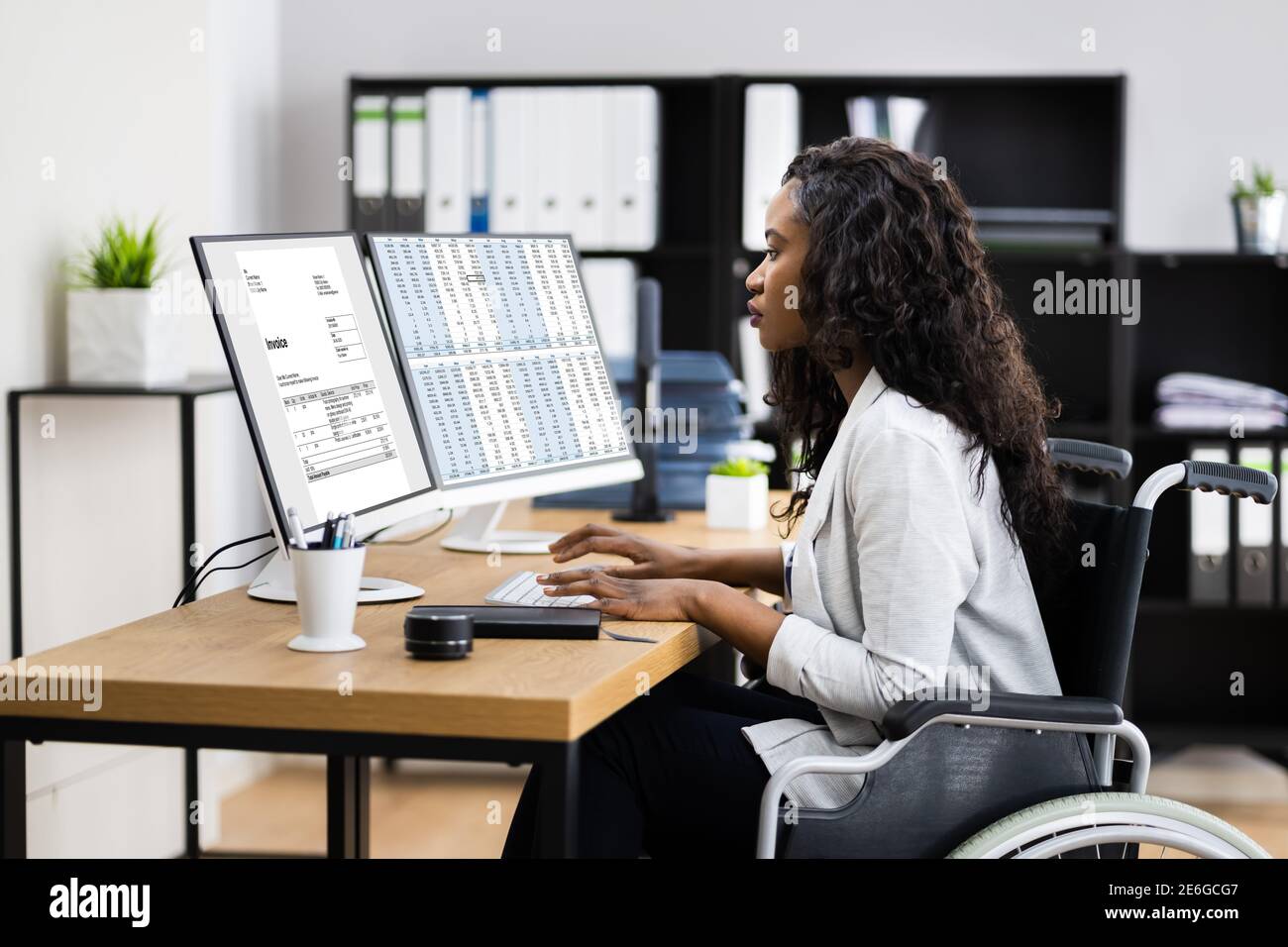 Disabled Person Working In Wheelchair In Office Stock Photo - Alamy