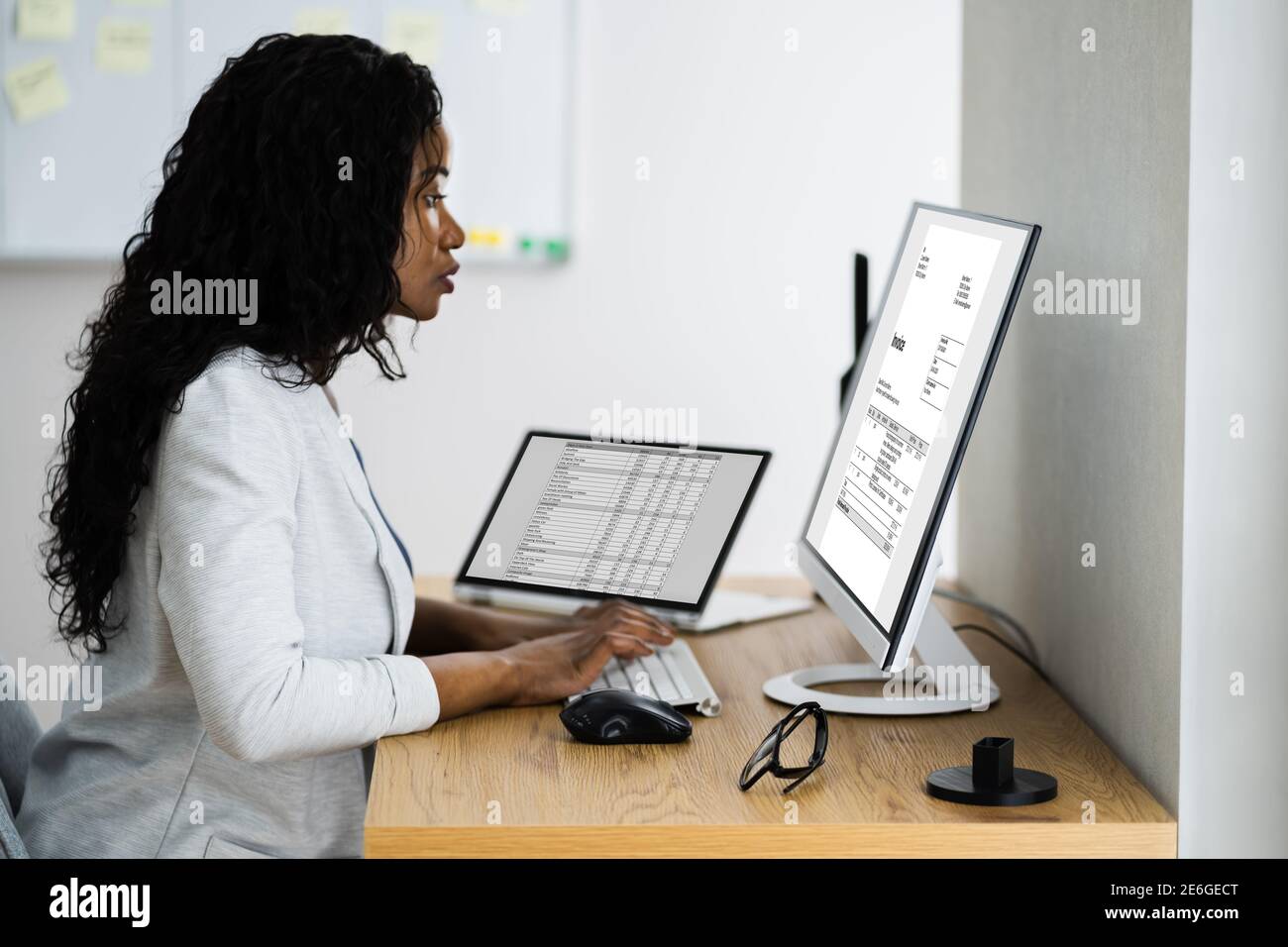 Woman Using Invoice Software On Multiple Computer Screens Stock Photo ...