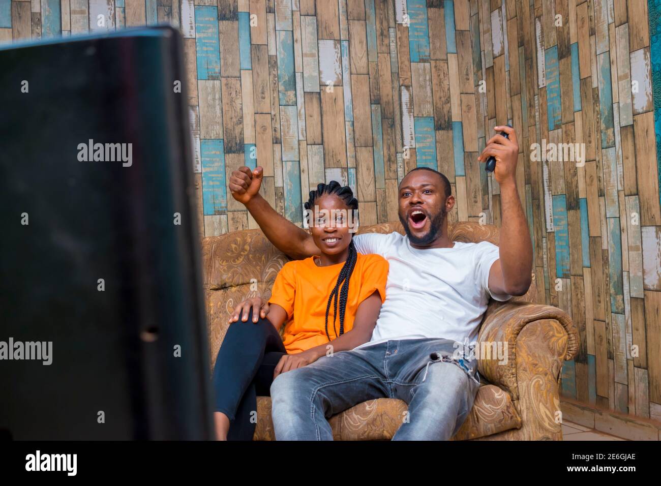 young black people isolated, watching television and having fun at home ...