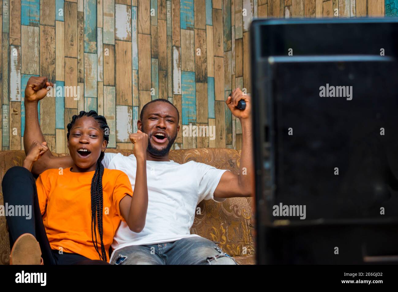 young black people isolated, watching television and having fun at home ...