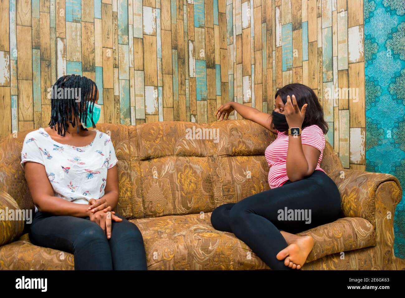 young black ladies sitting on a couch, discussing and making some jokes ...