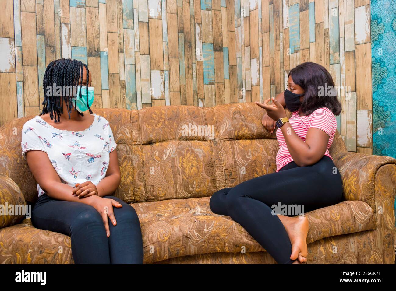young black ladies sitting on a couch, discussing and making some jokes ...