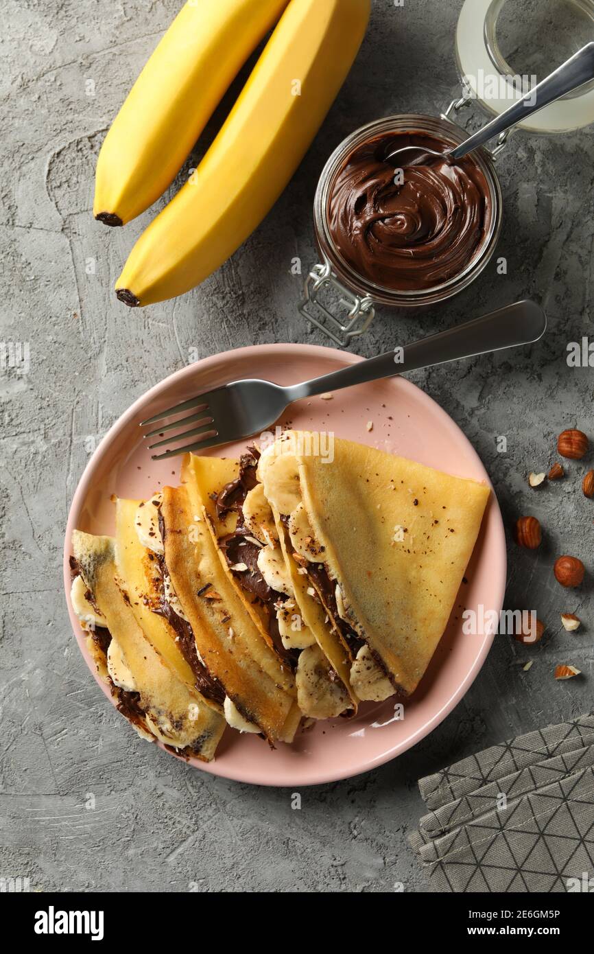 Concept of delicious breakfast with crepes with chocolate paste, banana ...