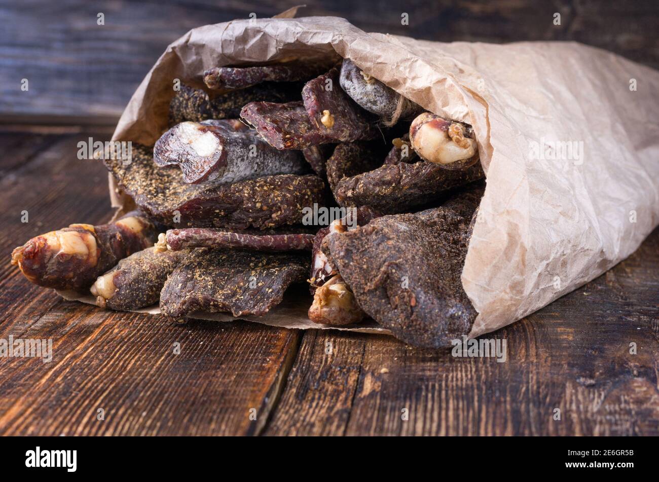 A paper craft bag filled with dried meat. Takeout products. Front view ...