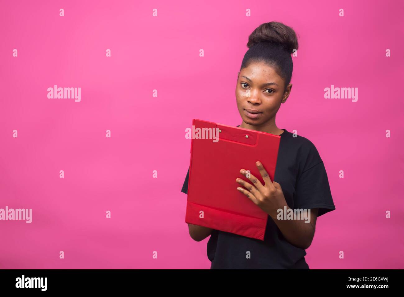 young beautiful black lady smiling while using her notepad to take note ...