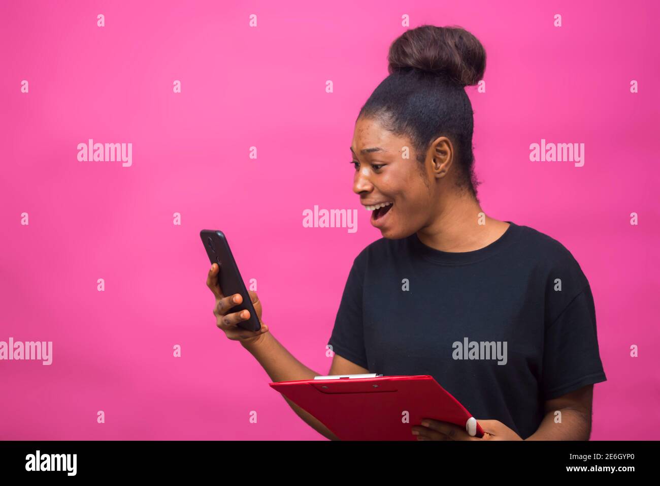 young beautiful black lady holding her notepad and happy over something ...