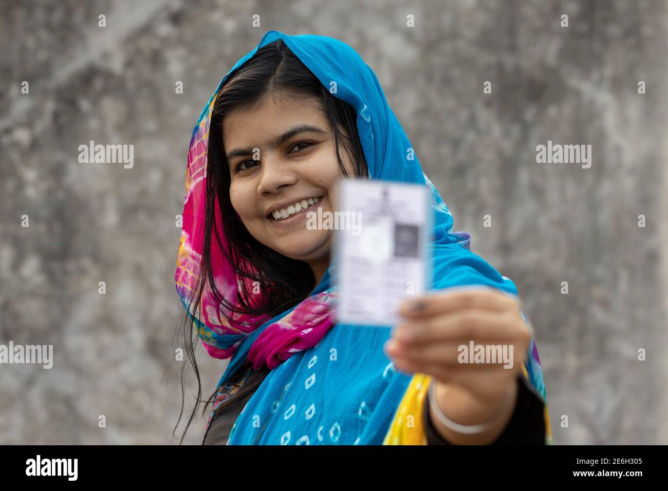 an Indian village woman with smiling face showing blurred voter card in ...