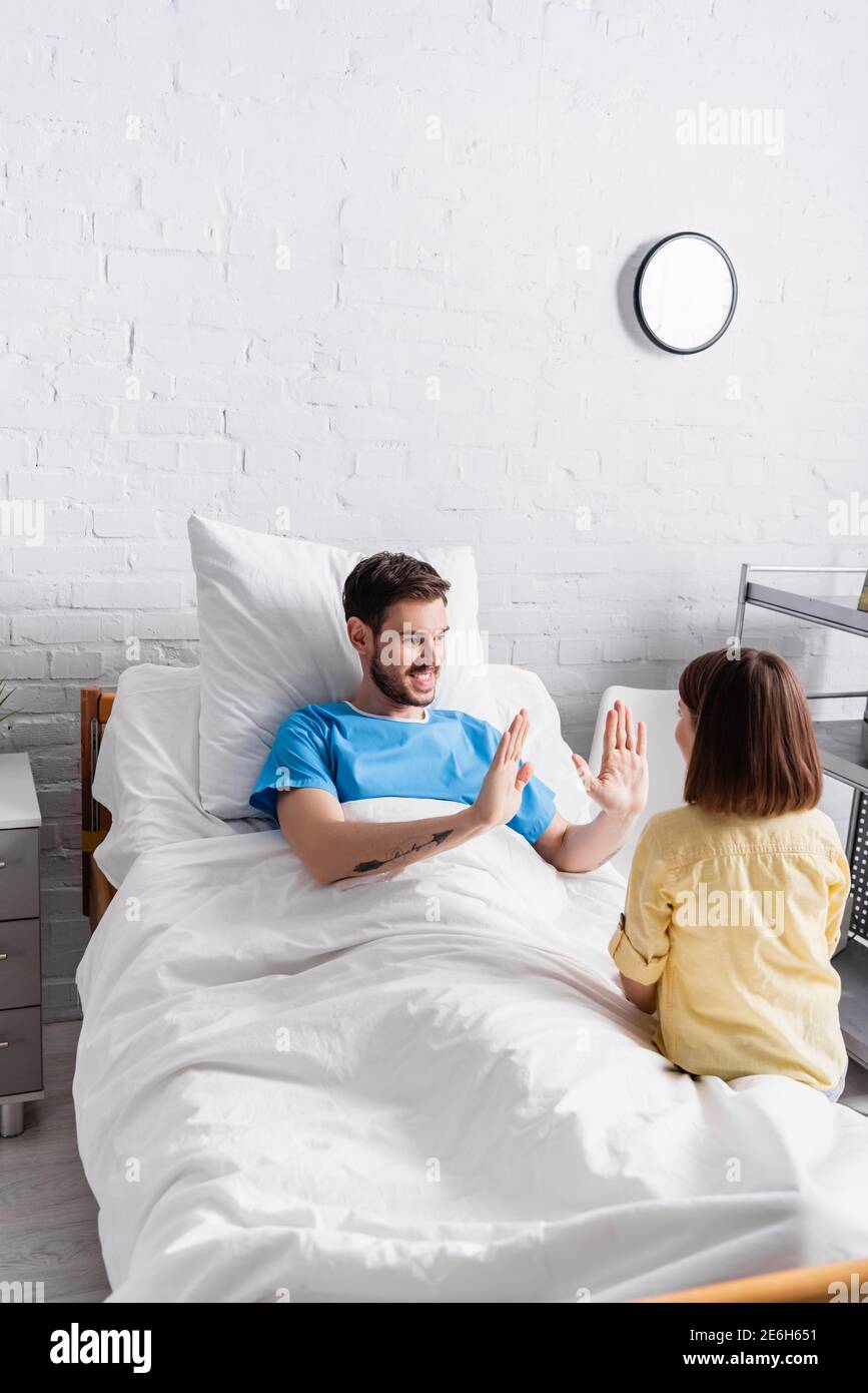 cheerful man playing patty-cake game with daughter in hospital Stock ...