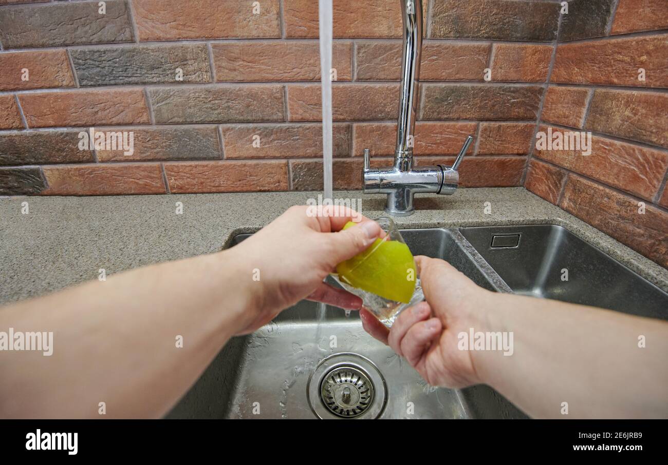 Washing glass in sink with sponge on modern kitchen background Stock ...