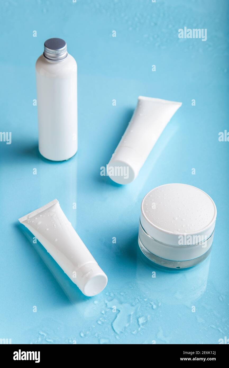 Set of white cosmetic products in tubes jar bottle on color blue ...