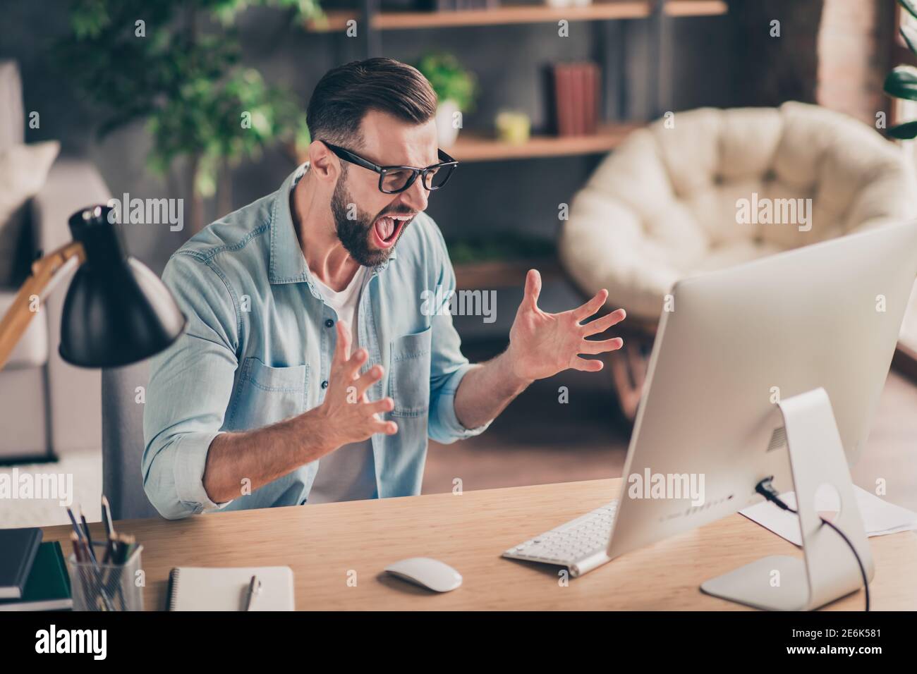 Photo portrait of guy screaming at computer screen on table in modern ...