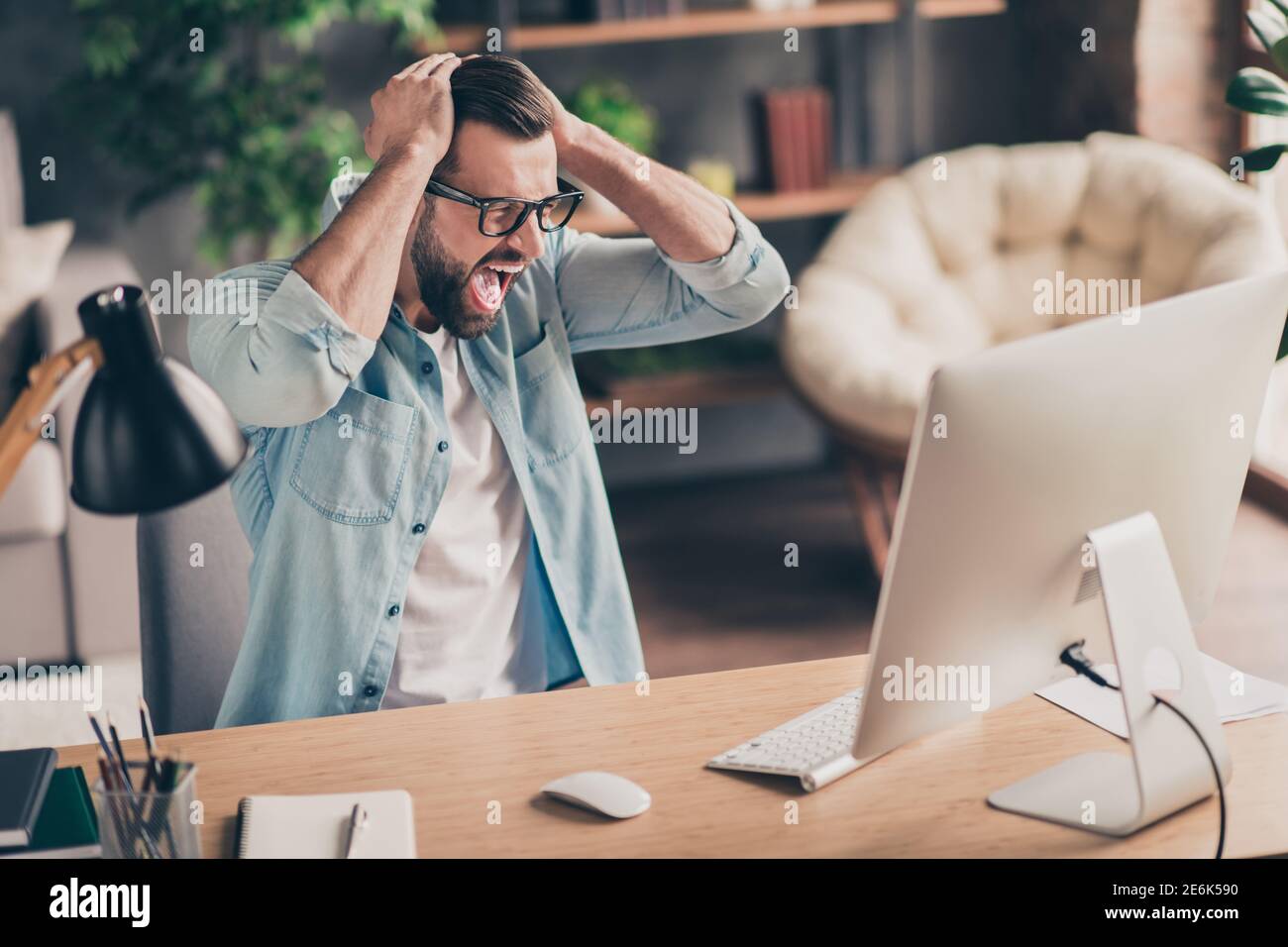 Photo portrait of unhappy man screaming at desktop screen holding head ...
