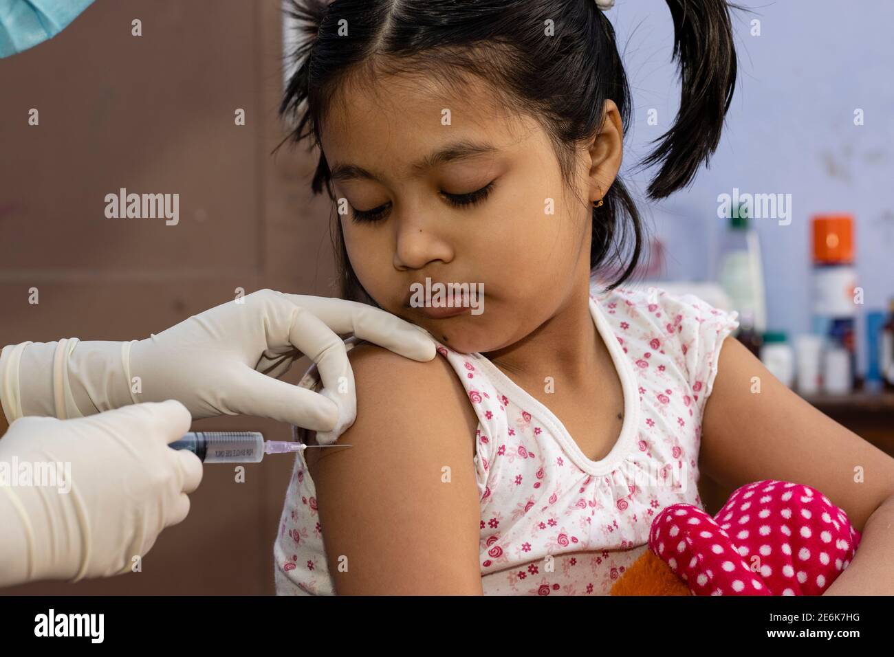 an Indian girl child looks at the needle during vaccination Stock Photo ...