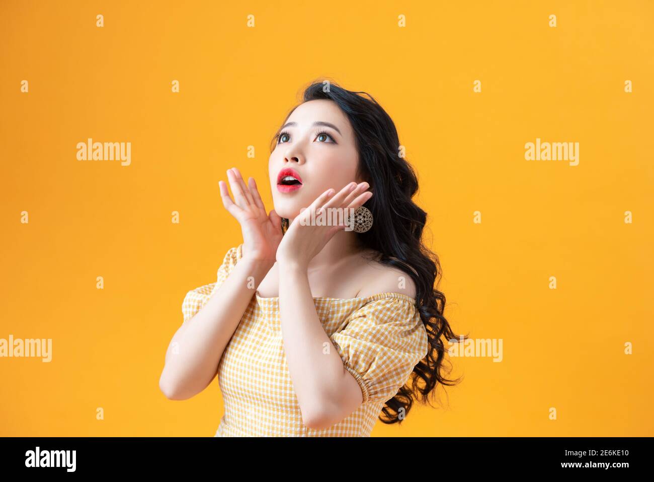 Asian girl is surprised she is excited.Yellow background studio Stock ...