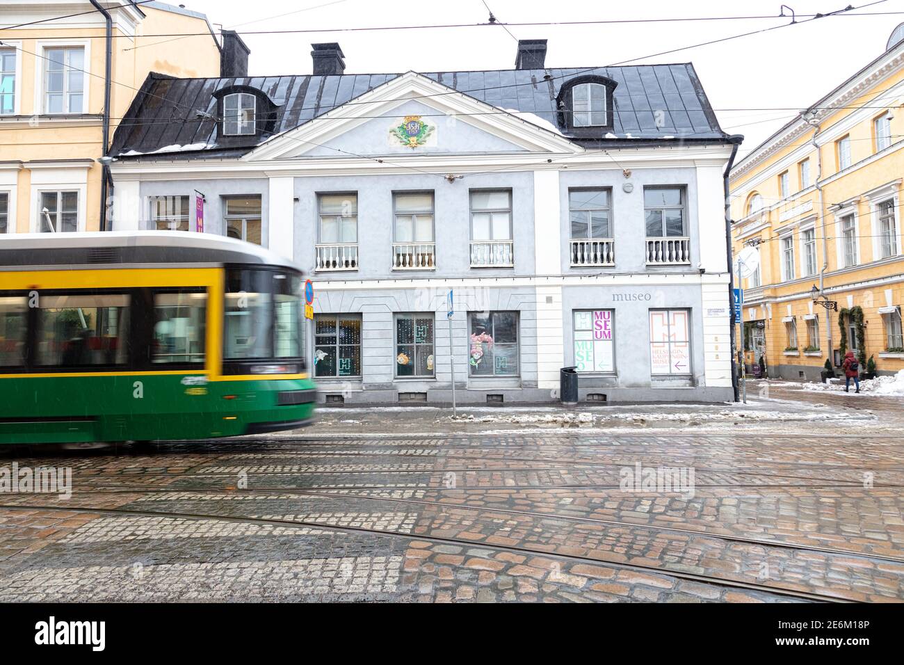 Finland, Helsinki. January 26, 2021 Green tram in front of a gray ...