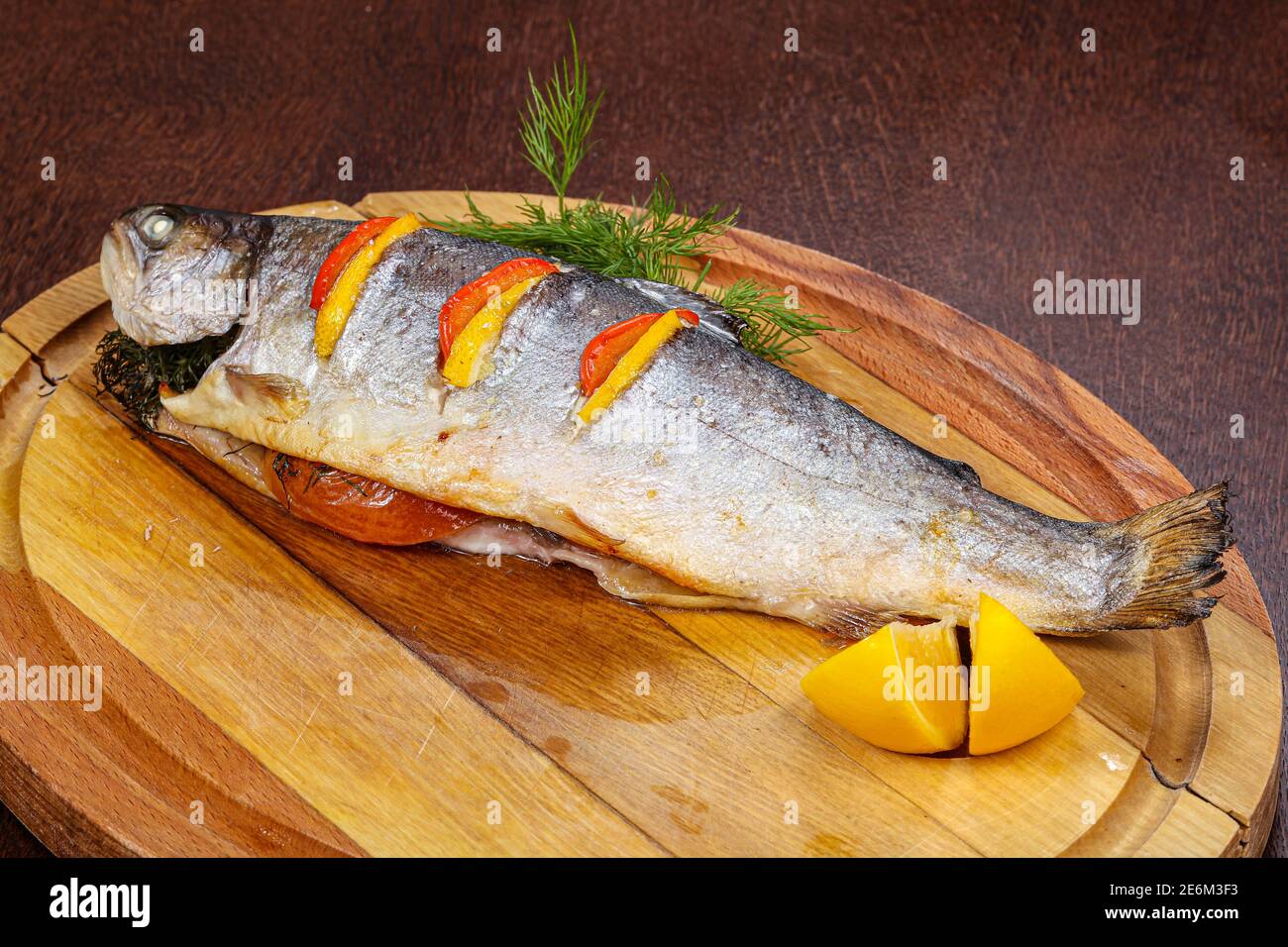 Baked trout staffed vegetables and served lemon Stock Photo - Alamy